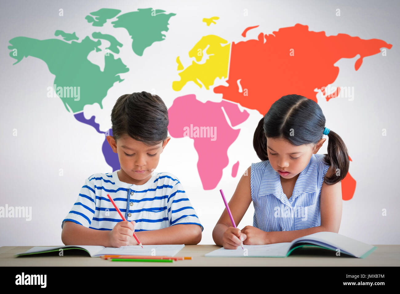 Children writing on books at table against grey background Stock Photo ...
