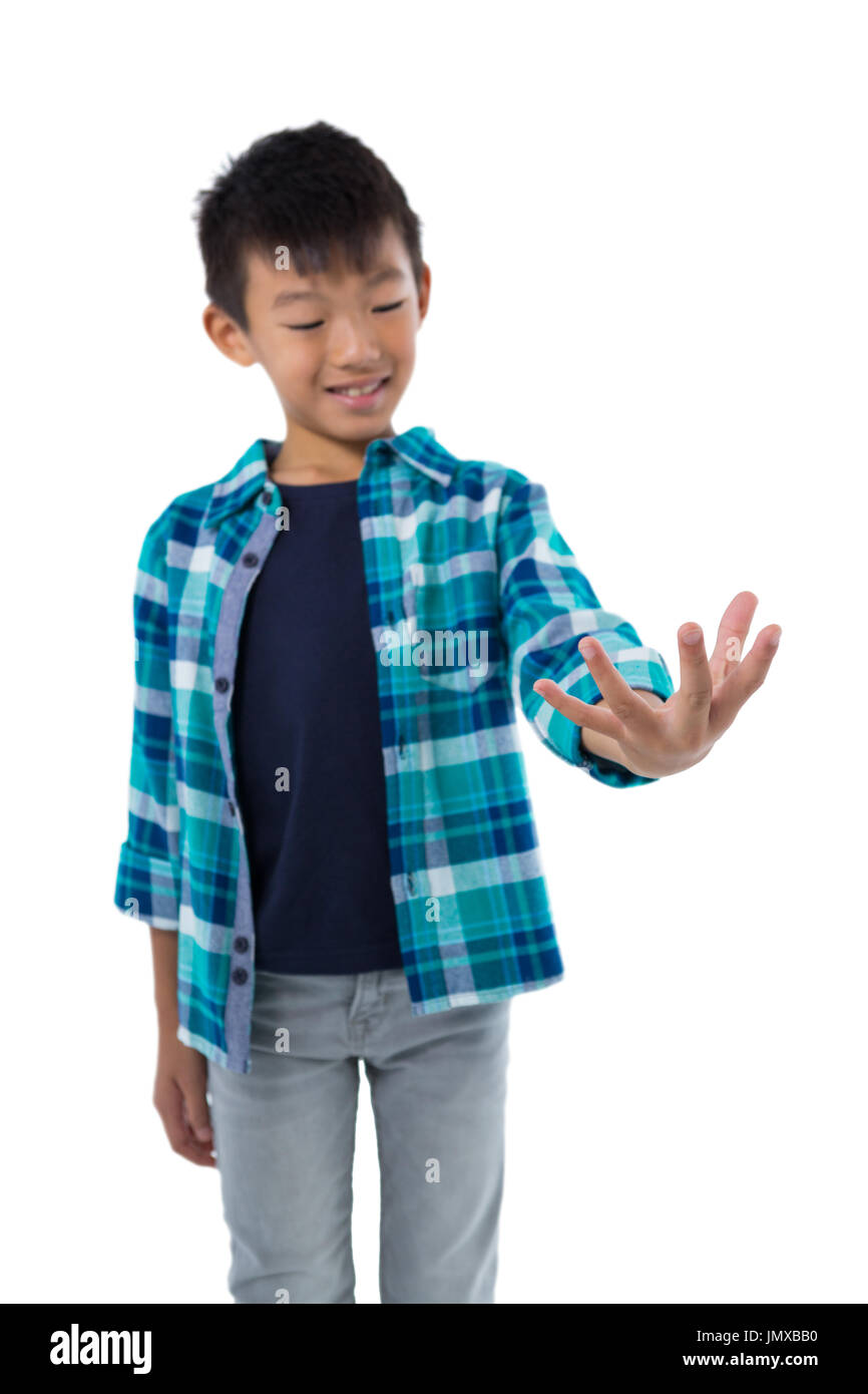 Boy pretending to hold invisible object against white background Stock ...