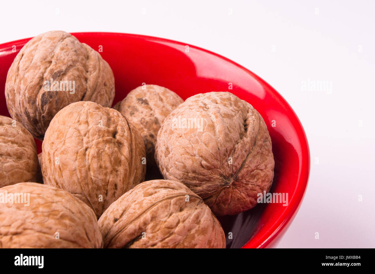 walnuts in red plate on white background Stock Photo - Alamy