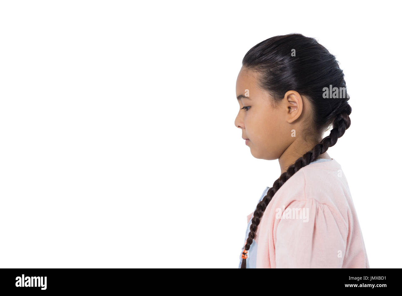 Side view of thoughtful girl standing against white background Stock ...