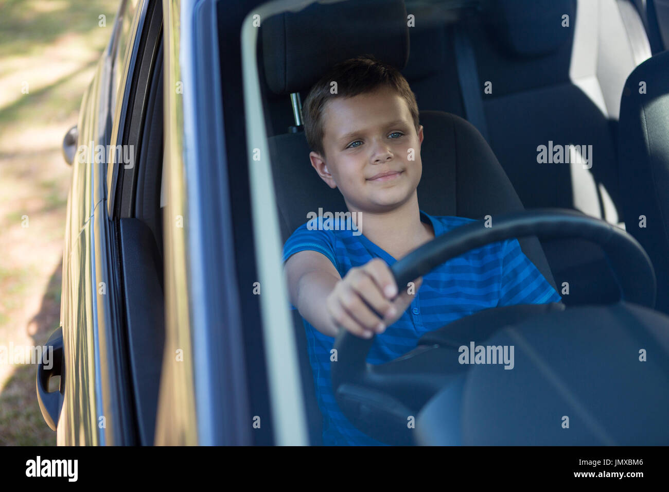 Smiling teenage boy driving a car Stock Photo - Alamy