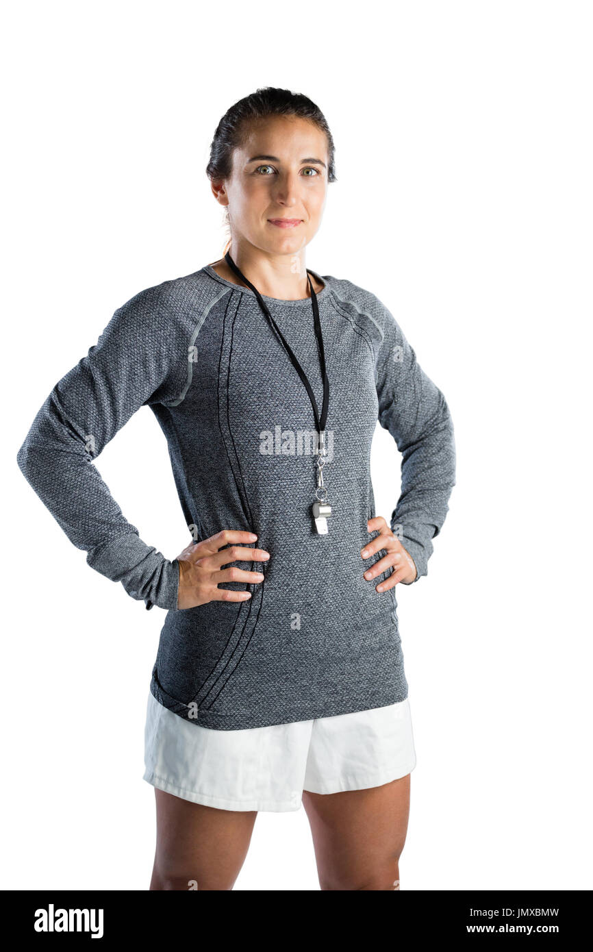 Portrait of smiling female coach with hands on hip standing against ...