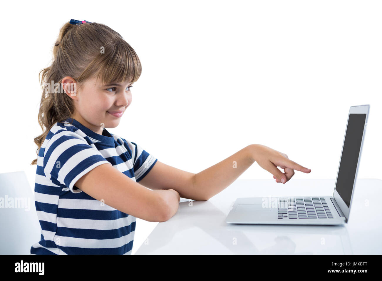 Cute girl using laptop at table against white background Stock Photo ...
