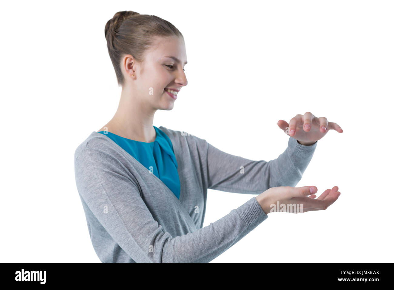 Smiling teenage girl pretending to hold invisible object Stock Photo ...