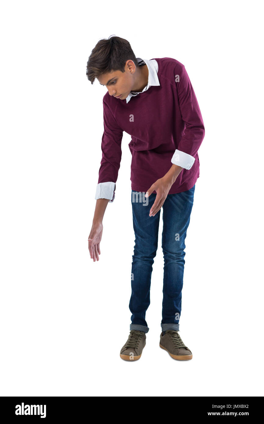 Thoughtful teenage boy looking down against white background Stock ...