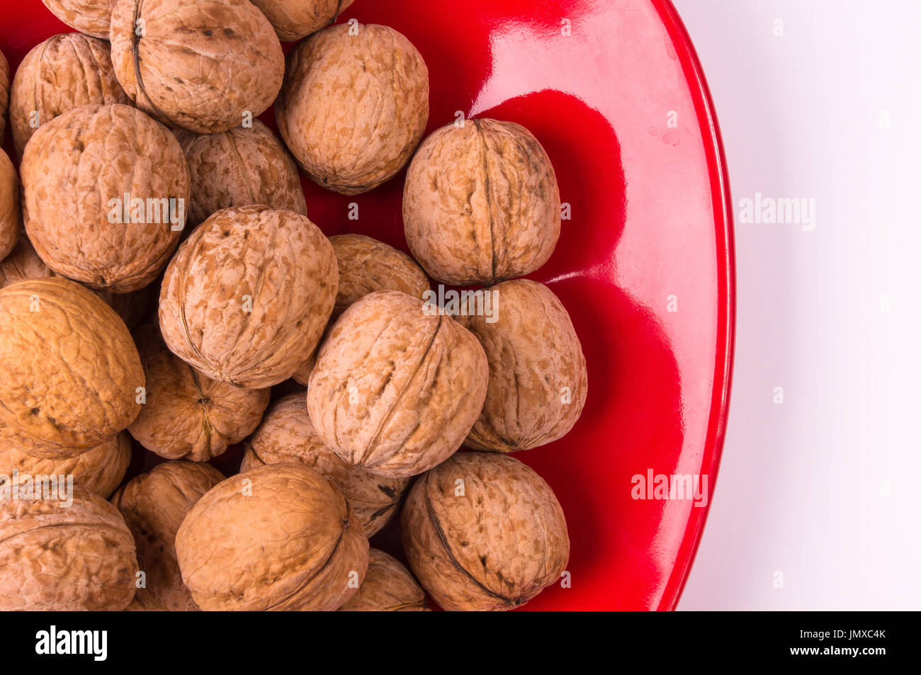 walnuts in red plate on white background Stock Photo - Alamy