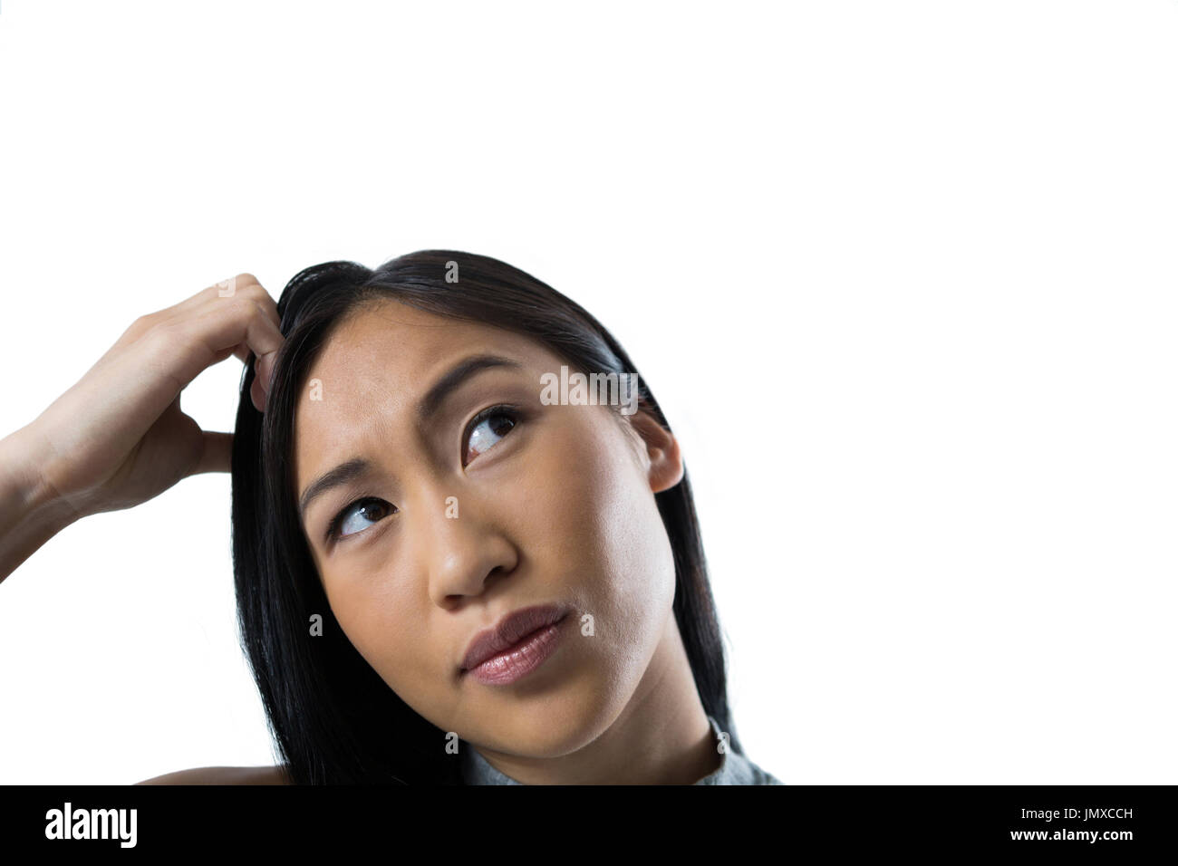 Confused woman standing against white background Stock Photo - Alamy