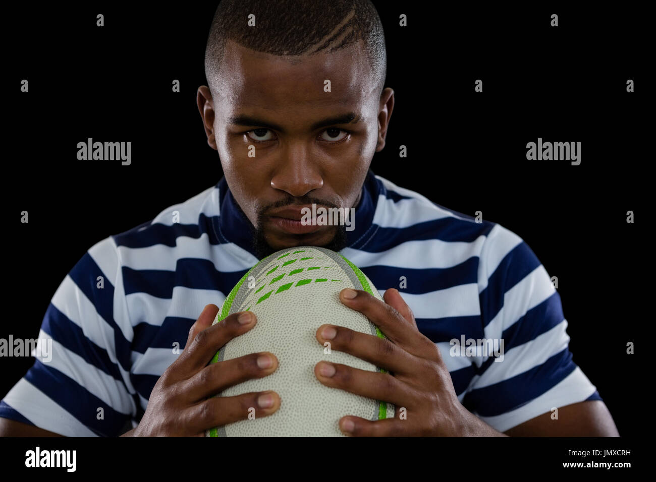 Close up portrait of serious male rugby player against black background ...