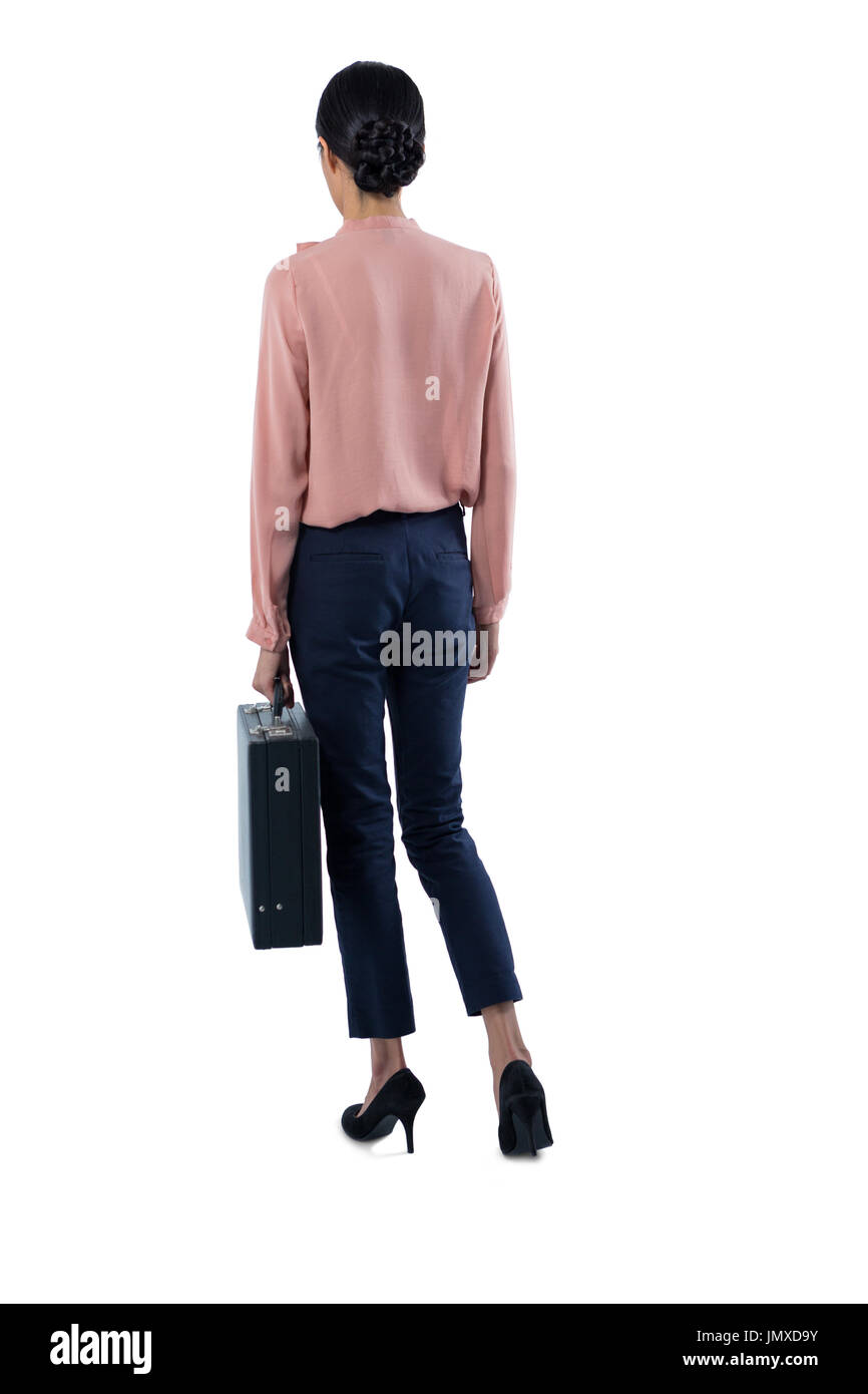 Rear view of female executive standing with briefcase on white ...