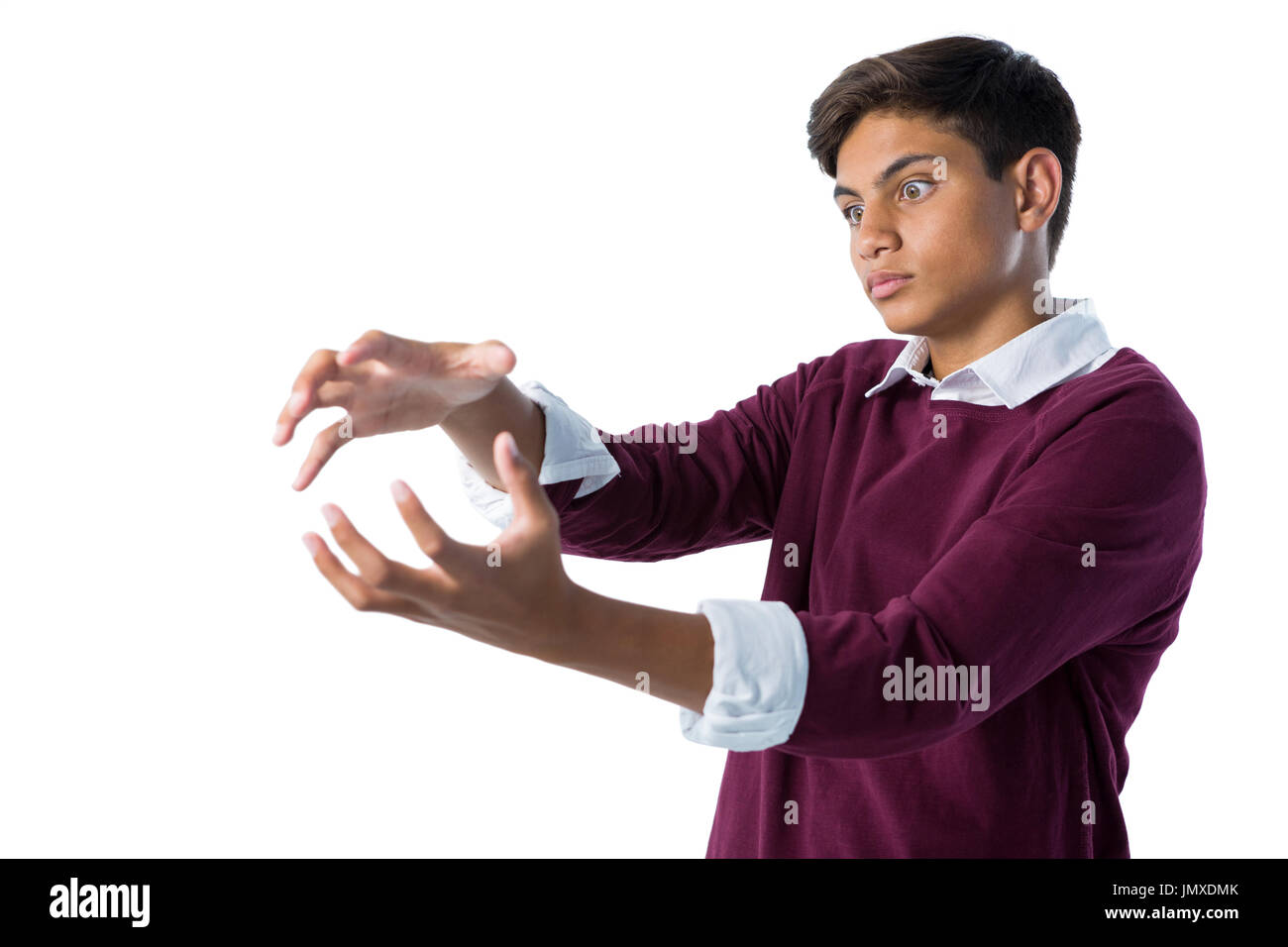 Teenage boy pretending to hold an invisible object against white ...