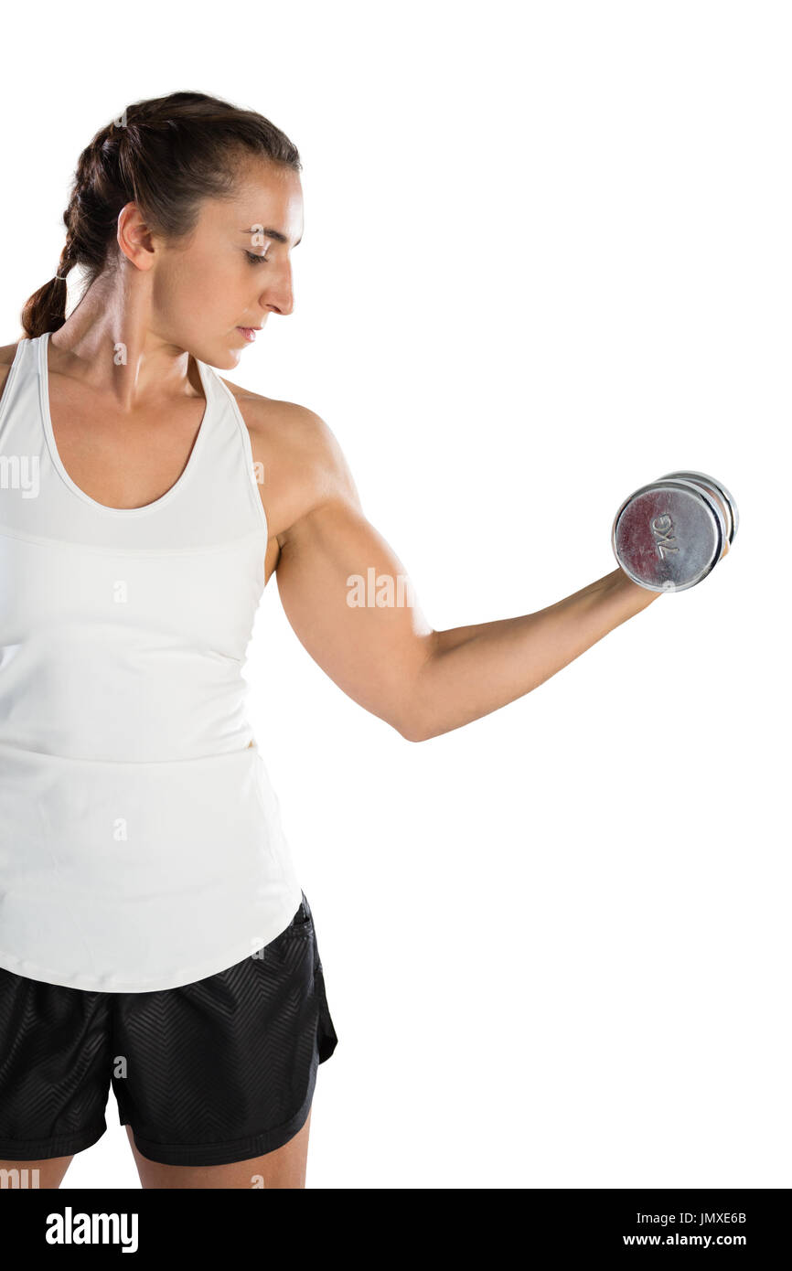 Young female rugby player lifting dumbbell while against white ...