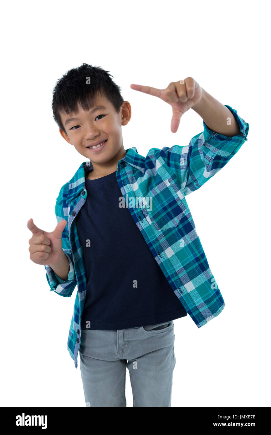 Portrait of boy forming a finger frame against white background Stock ...