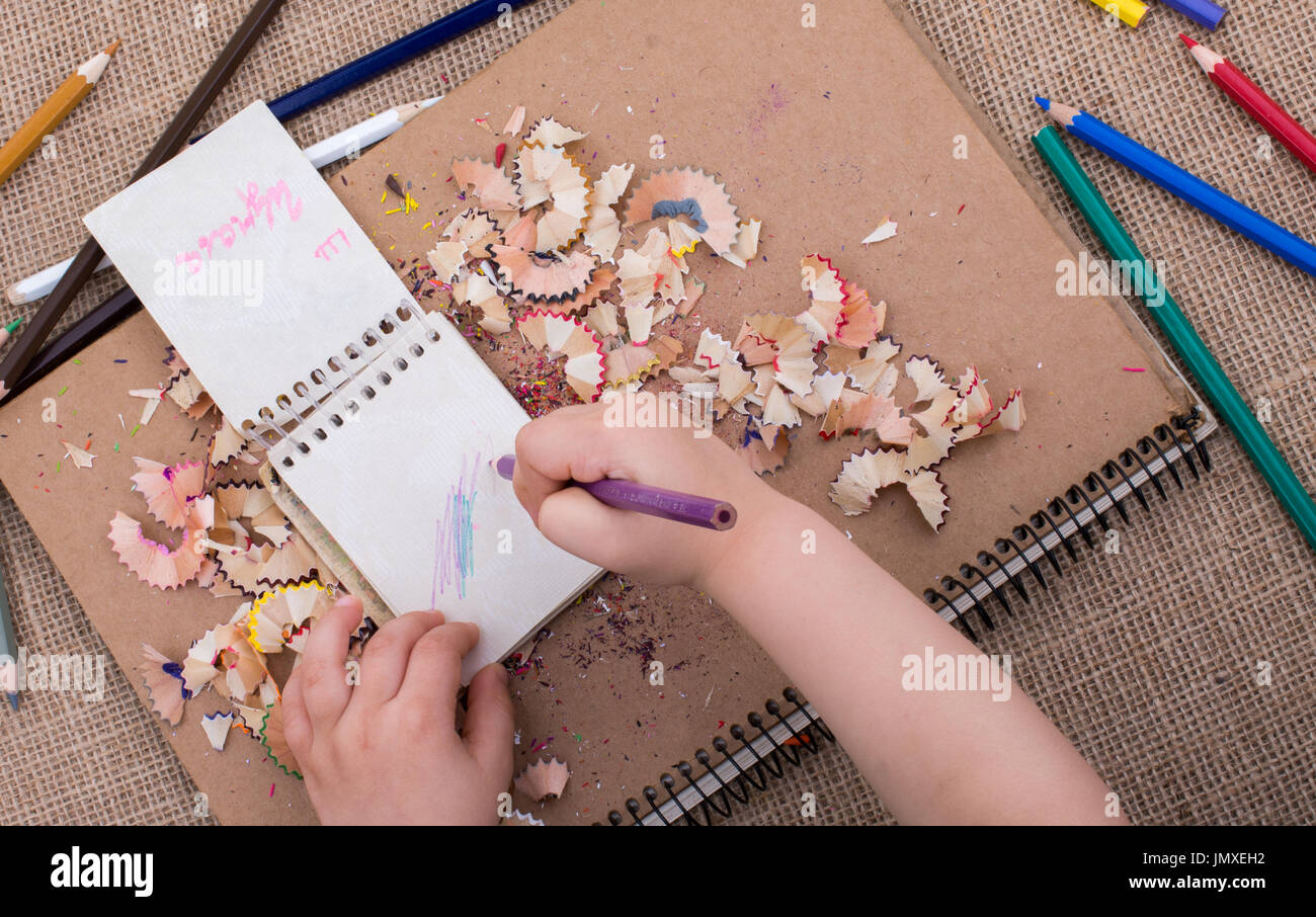 Hand holding a color pencil on spiral notebooks with pencil trash Stock ...