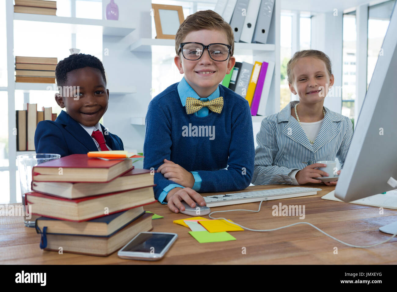 Portrait of kids as business executives working together in office ...