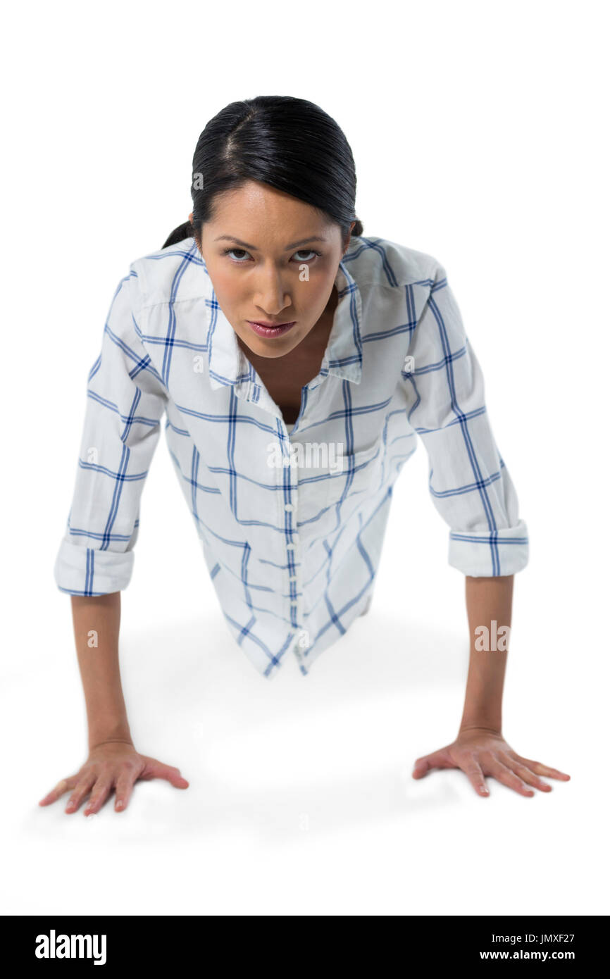 Portrait of woman performing push-ups against white background Stock ...