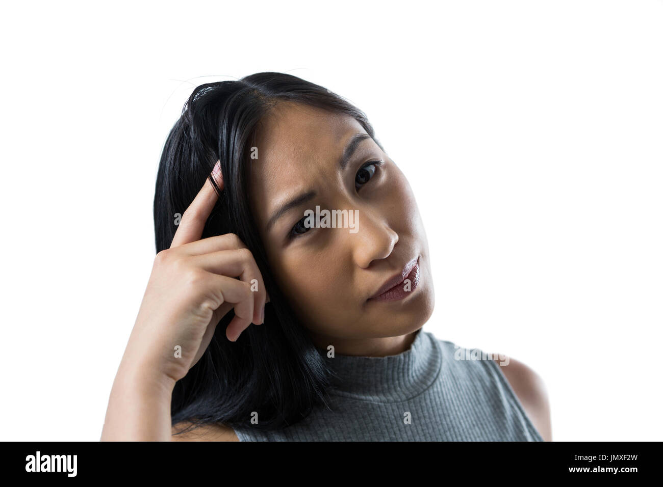 Confused woman standing against white background Stock Photo - Alamy