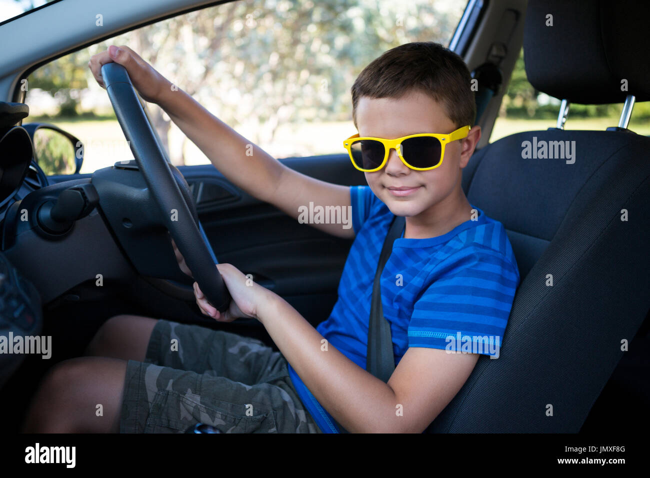 Smiling teenage boy driving a car Stock Photo - Alamy