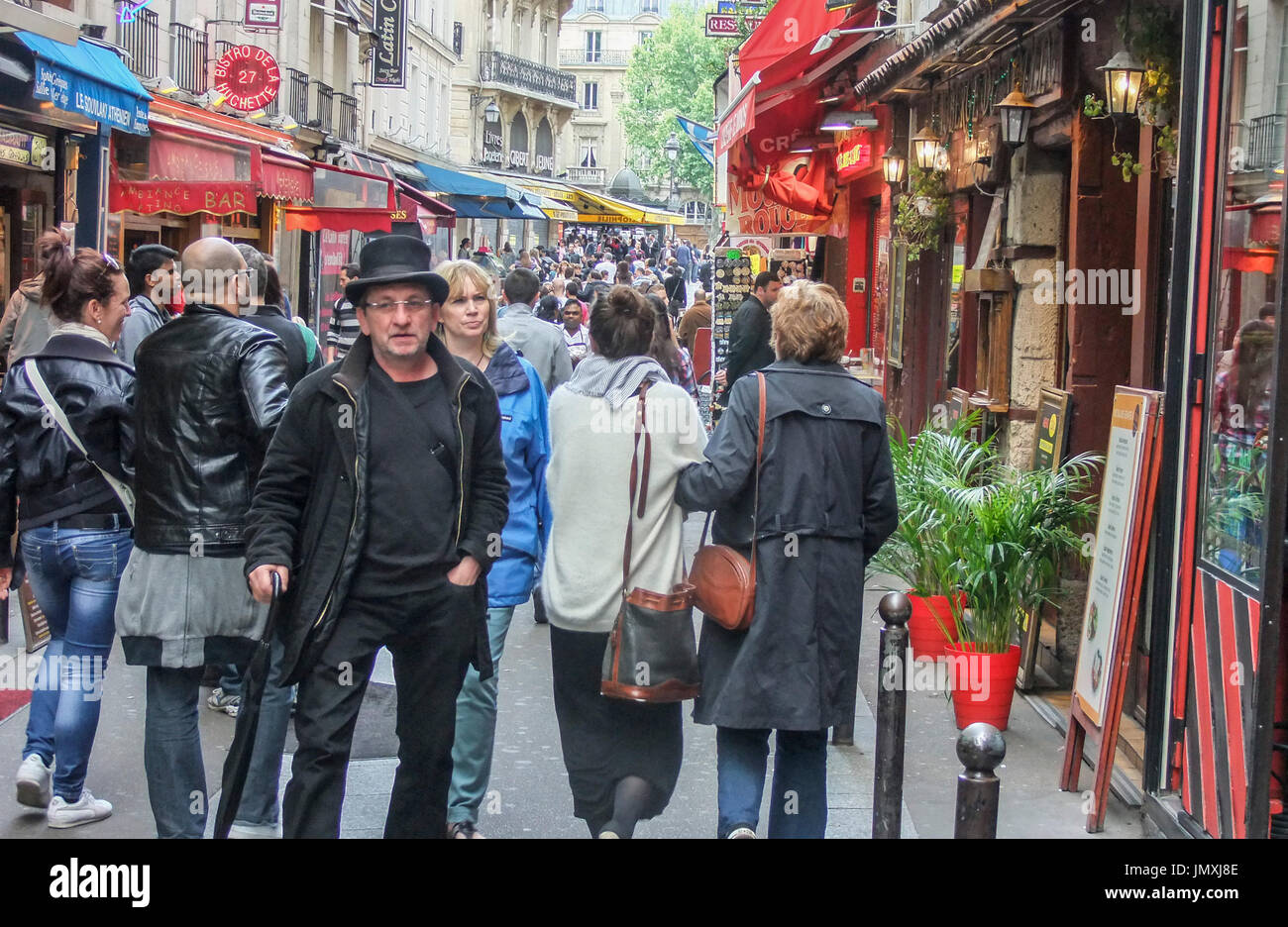 Crowded street scene in the centre of Paris,France. Man in top hat ...