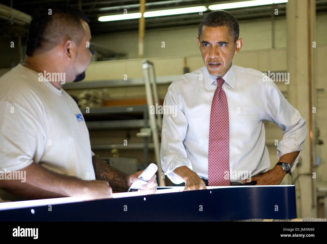 United States President Barack Obama speaks to a worker during a tour ...