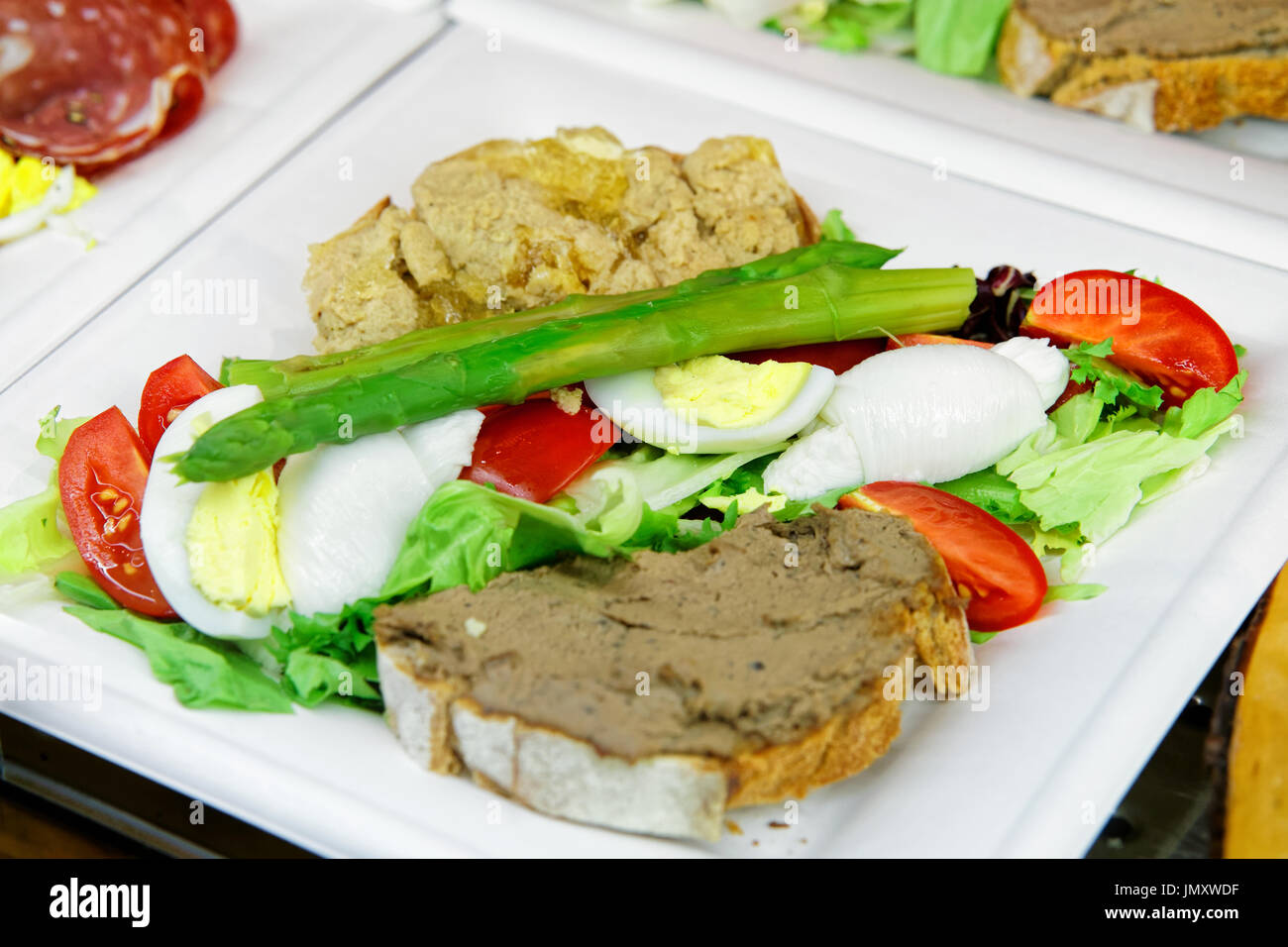 Traditional Italian platter with tomato, cheese, bread and fois gras on ...