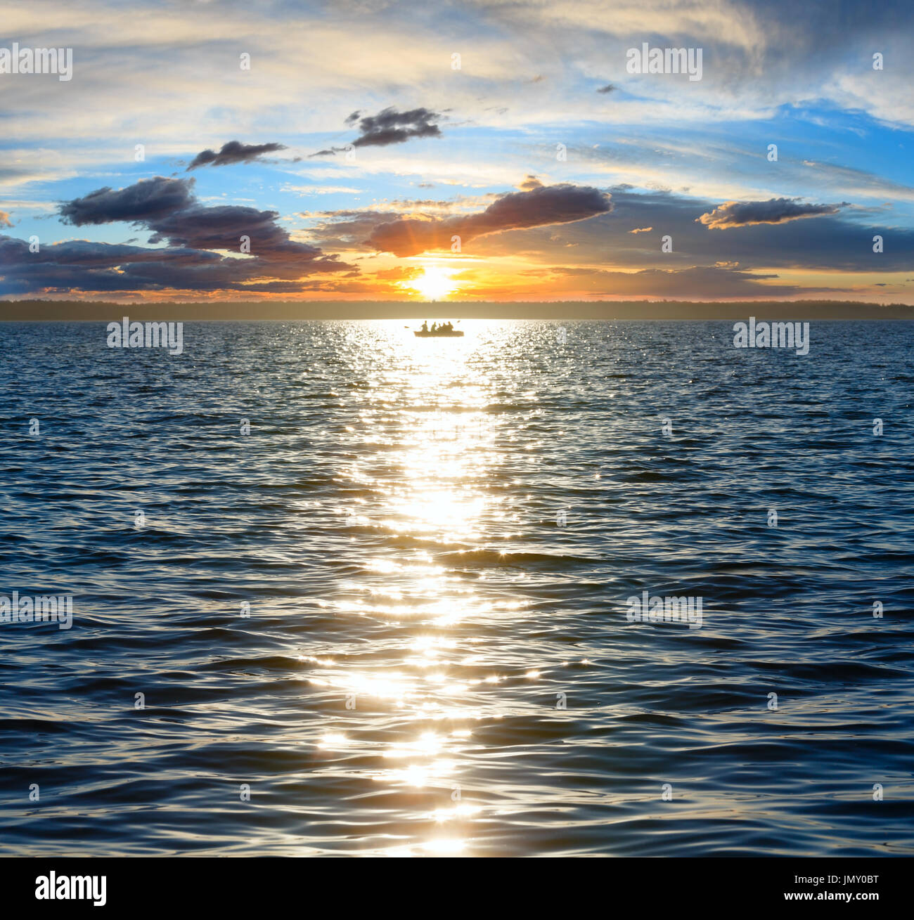 Sunset picturesque sky, sun track and fishing boat on summer lake ... Sunset picturesque sky, sun track and fishing boat on summer lake ...