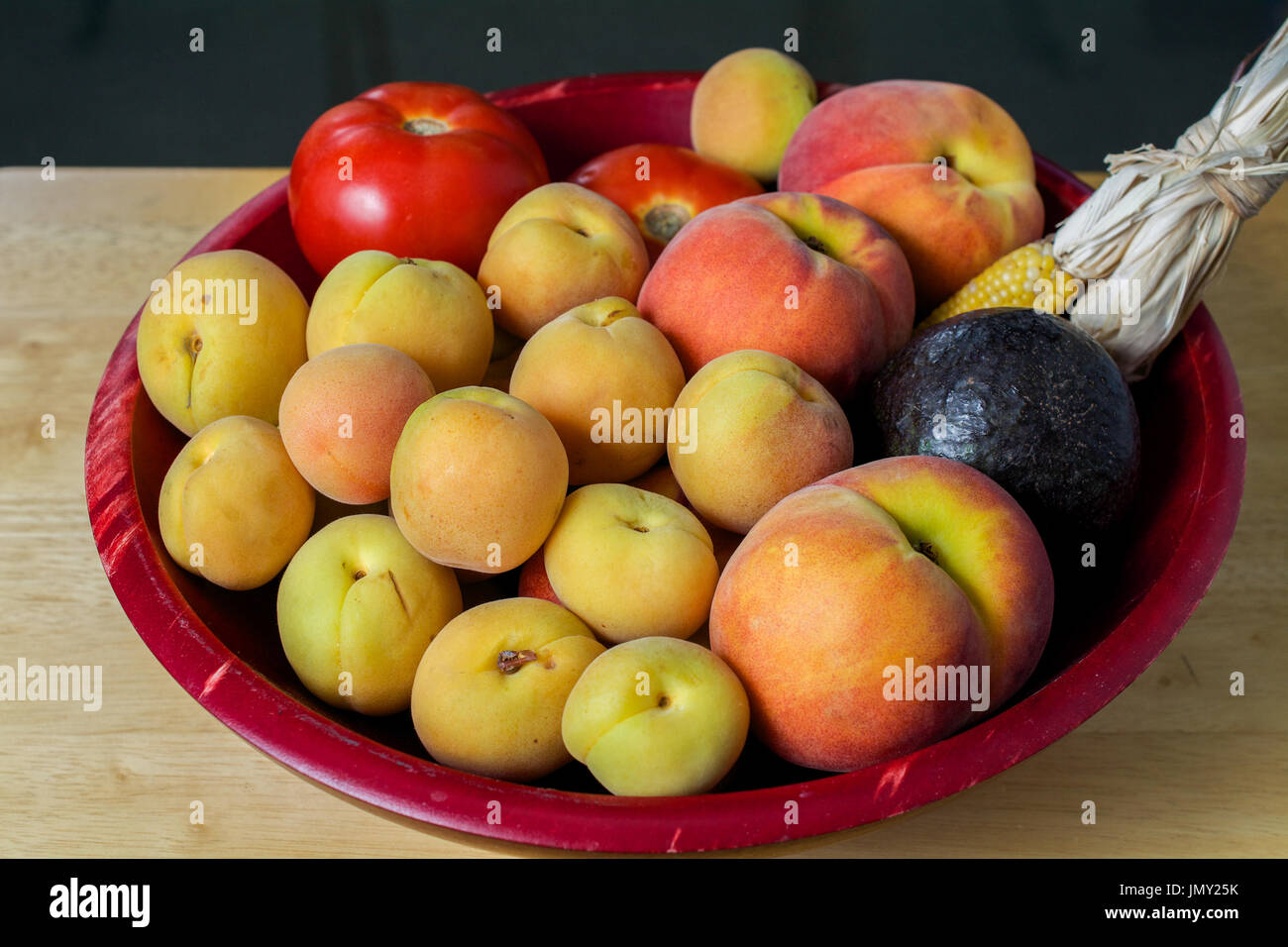 A bowl of fruits harvested in California in the summer, in red basket ...
