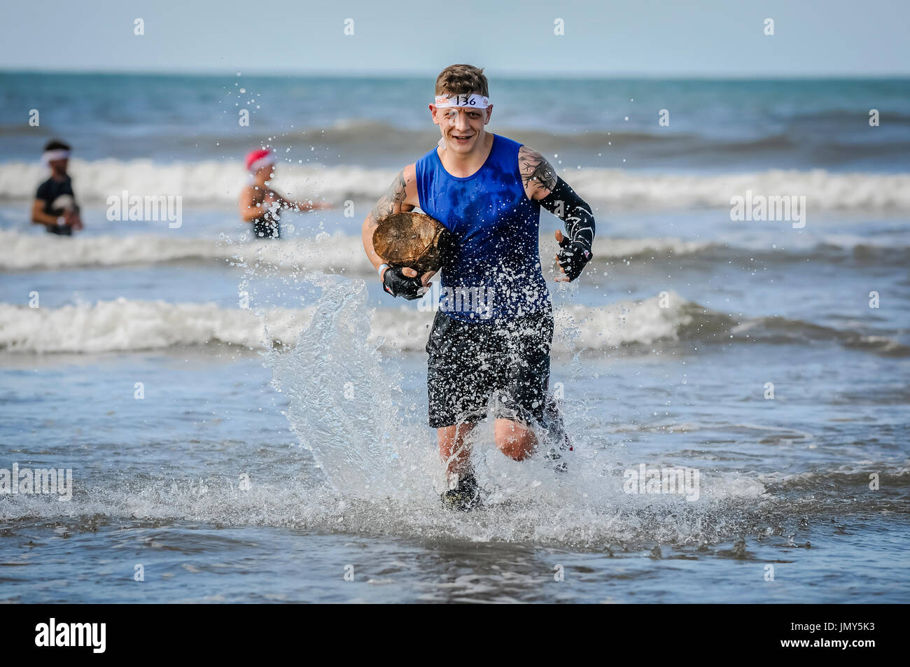 Log carry into the sea, unusual obstacle on obstacle course race Stock ...