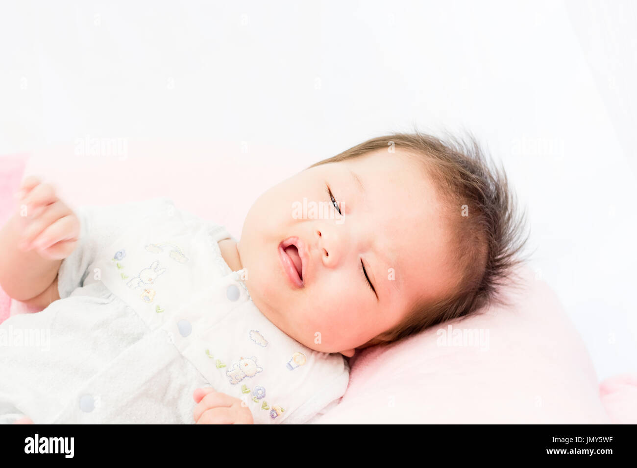 Portrait of a little adorable infant baby girl lying on back on the ...