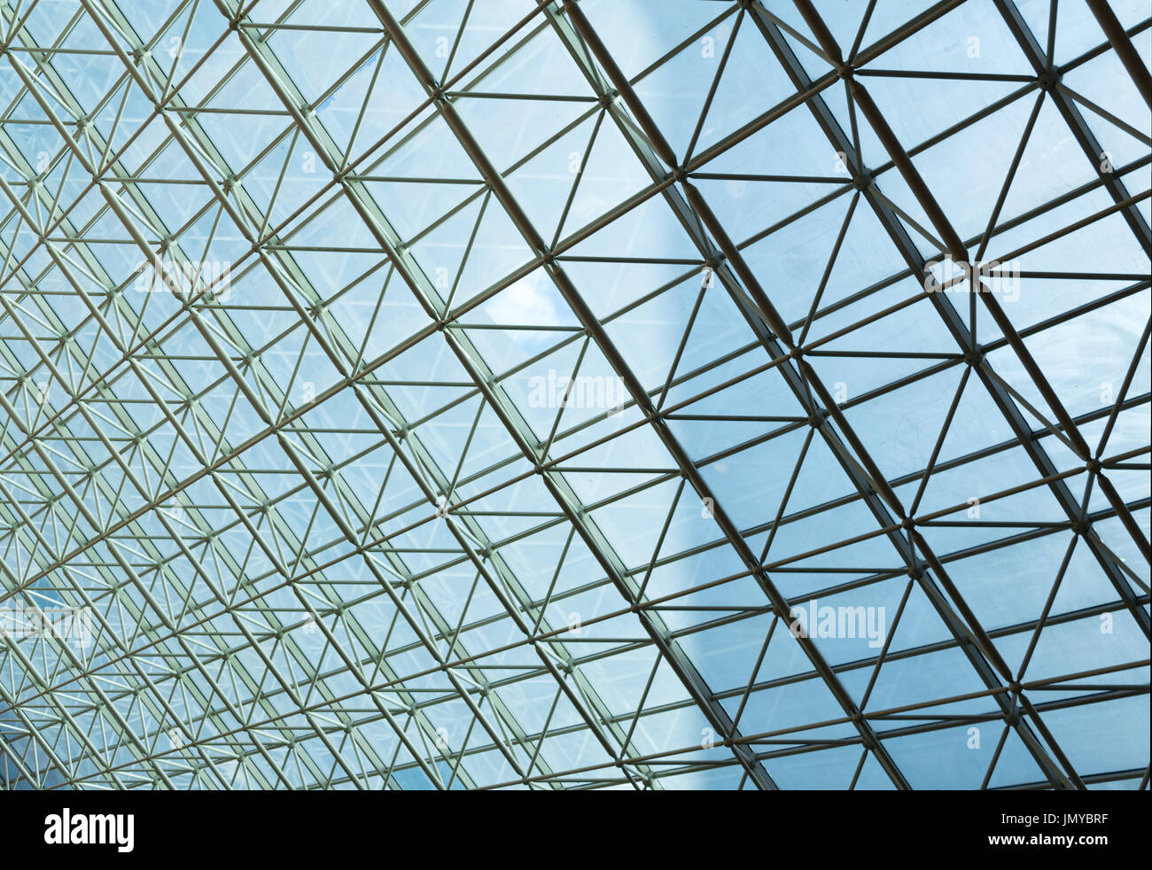Contemporary steel structure and transparent glass roof revealing blue ...