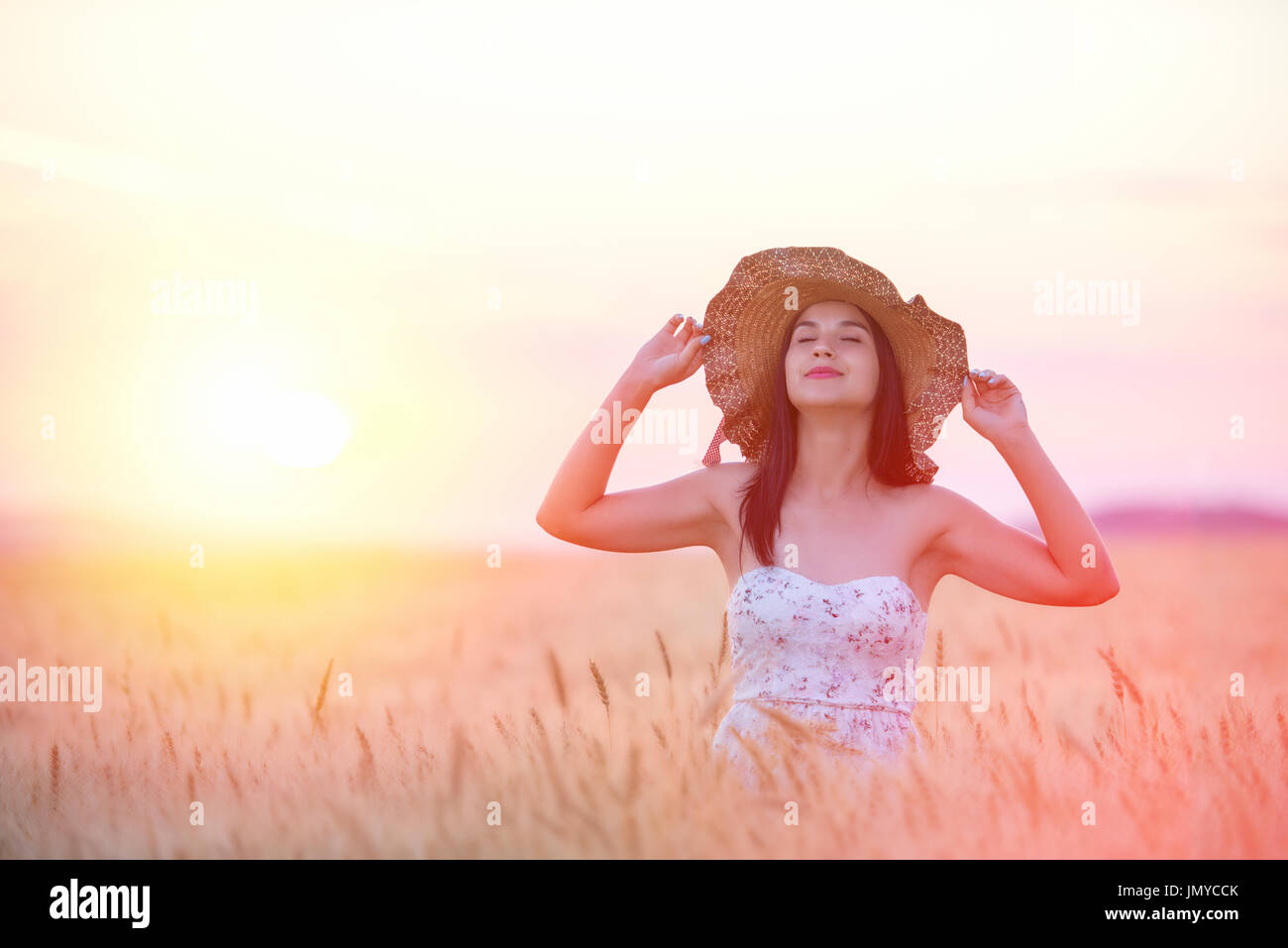 beautiful woman with summer hat in wheat field at sunset Stock Photo ...