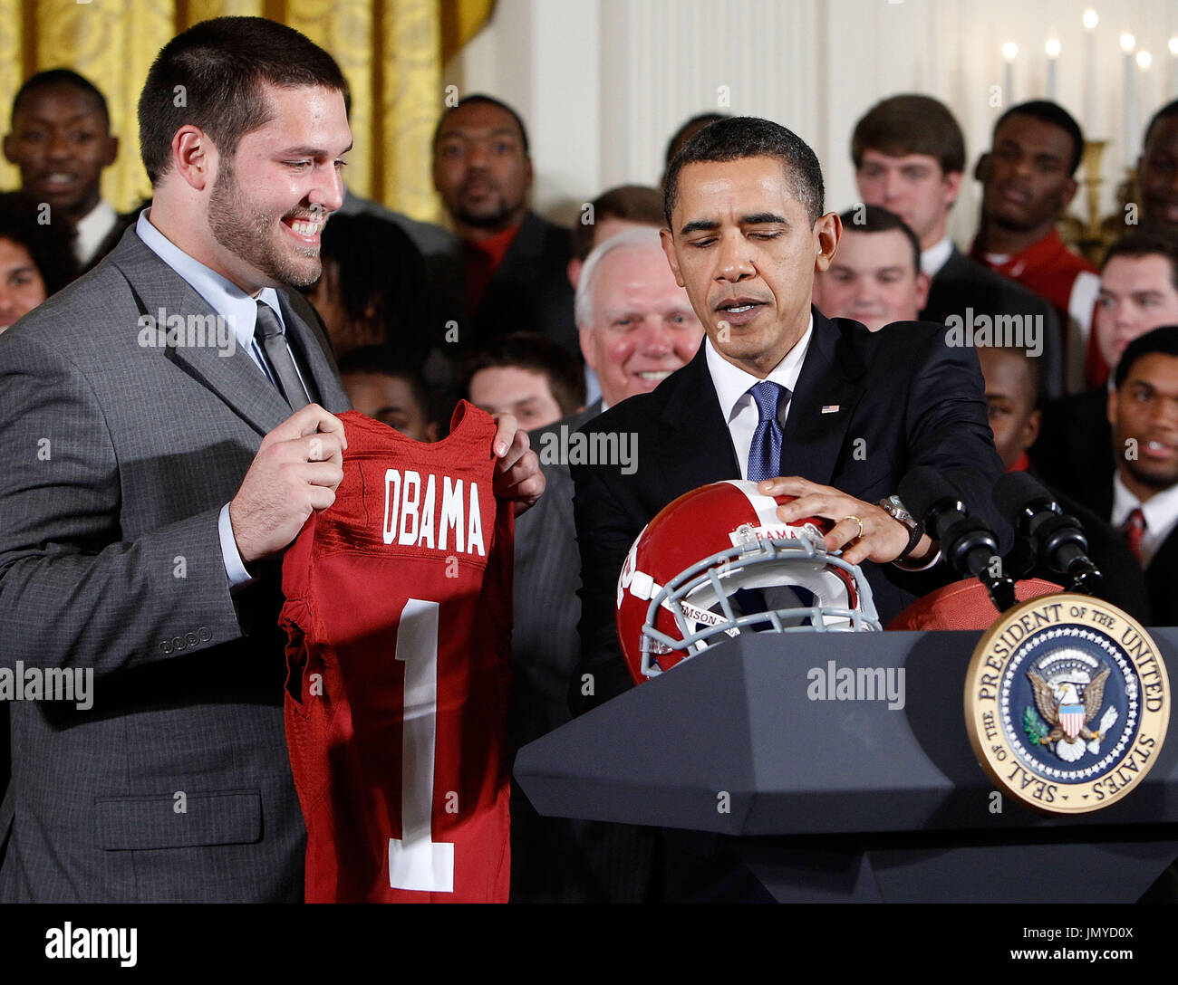 United States President Barack Obama (R) receives a football helmet as ...