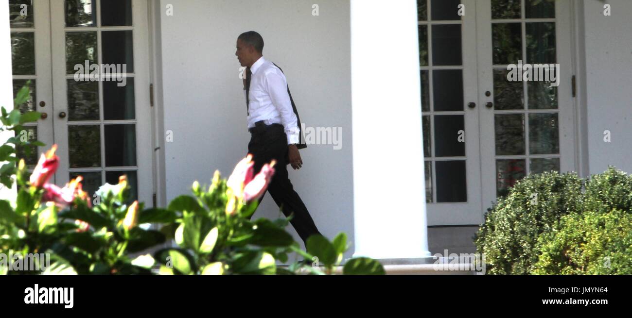 With his coat over his shoulder United States President Barack Obama ...