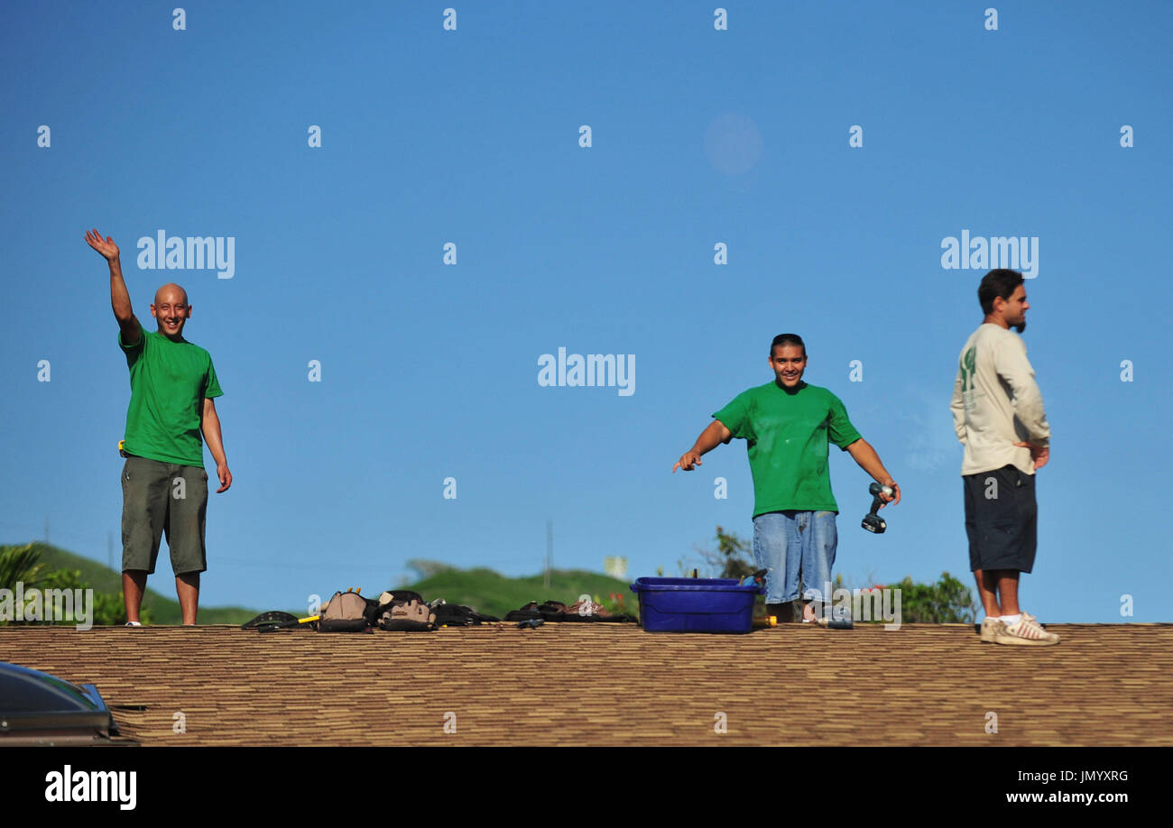 Roofing workers wave to United States President Barack Obama's ...