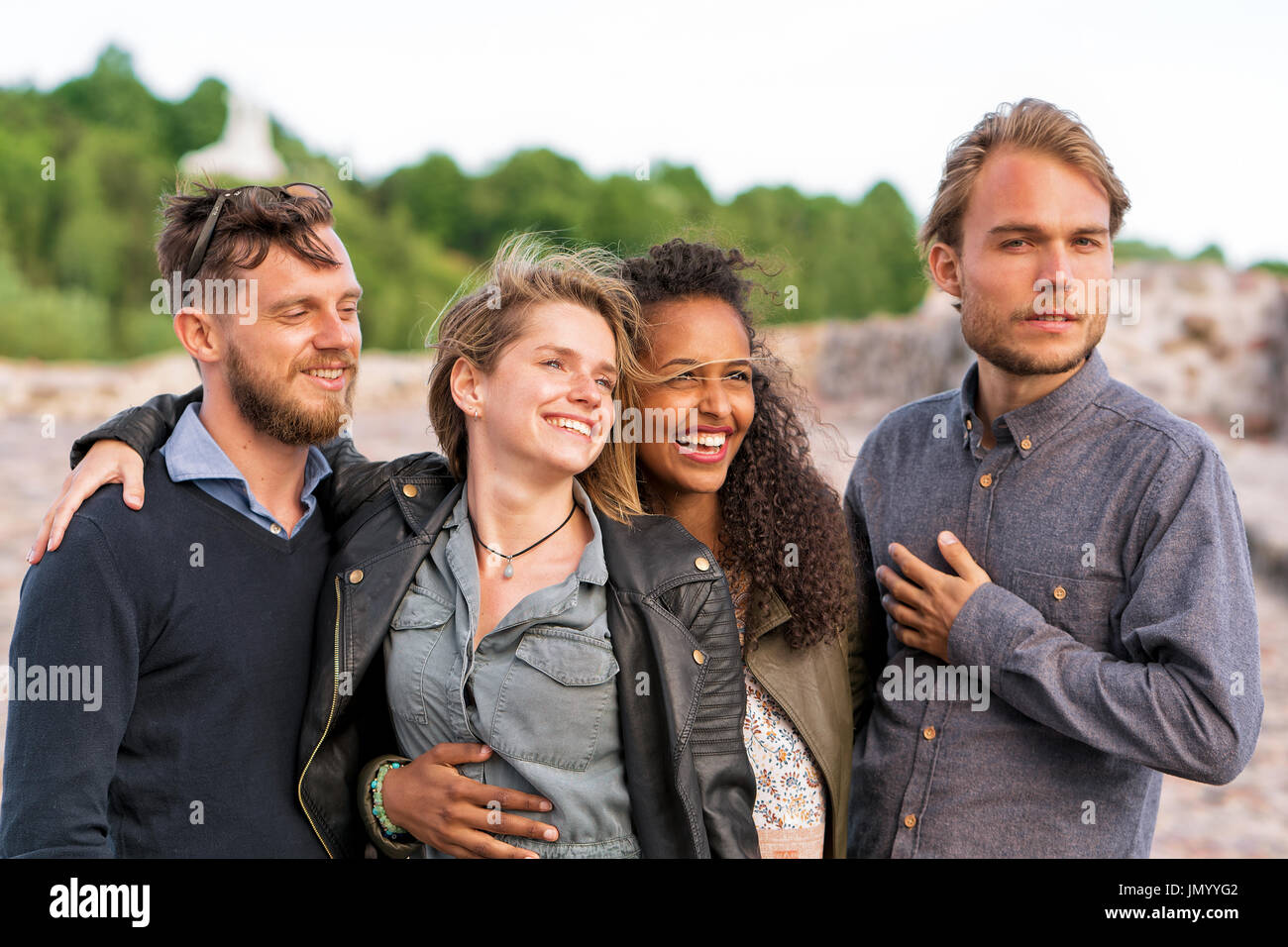 Group of young multiracial friends standing close to each other as a ...