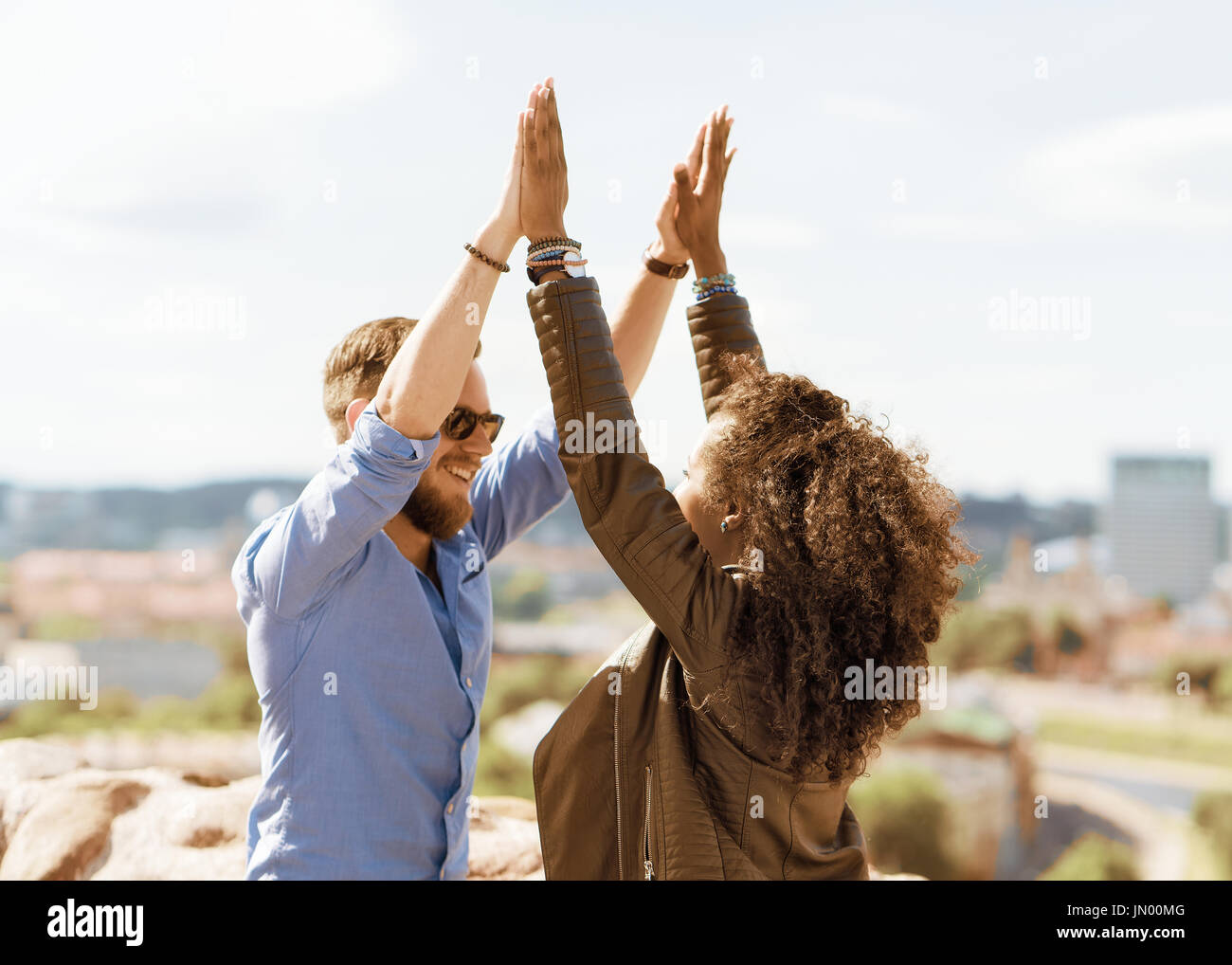 Young multiracial couple clapping their hands romantically as diversity ...