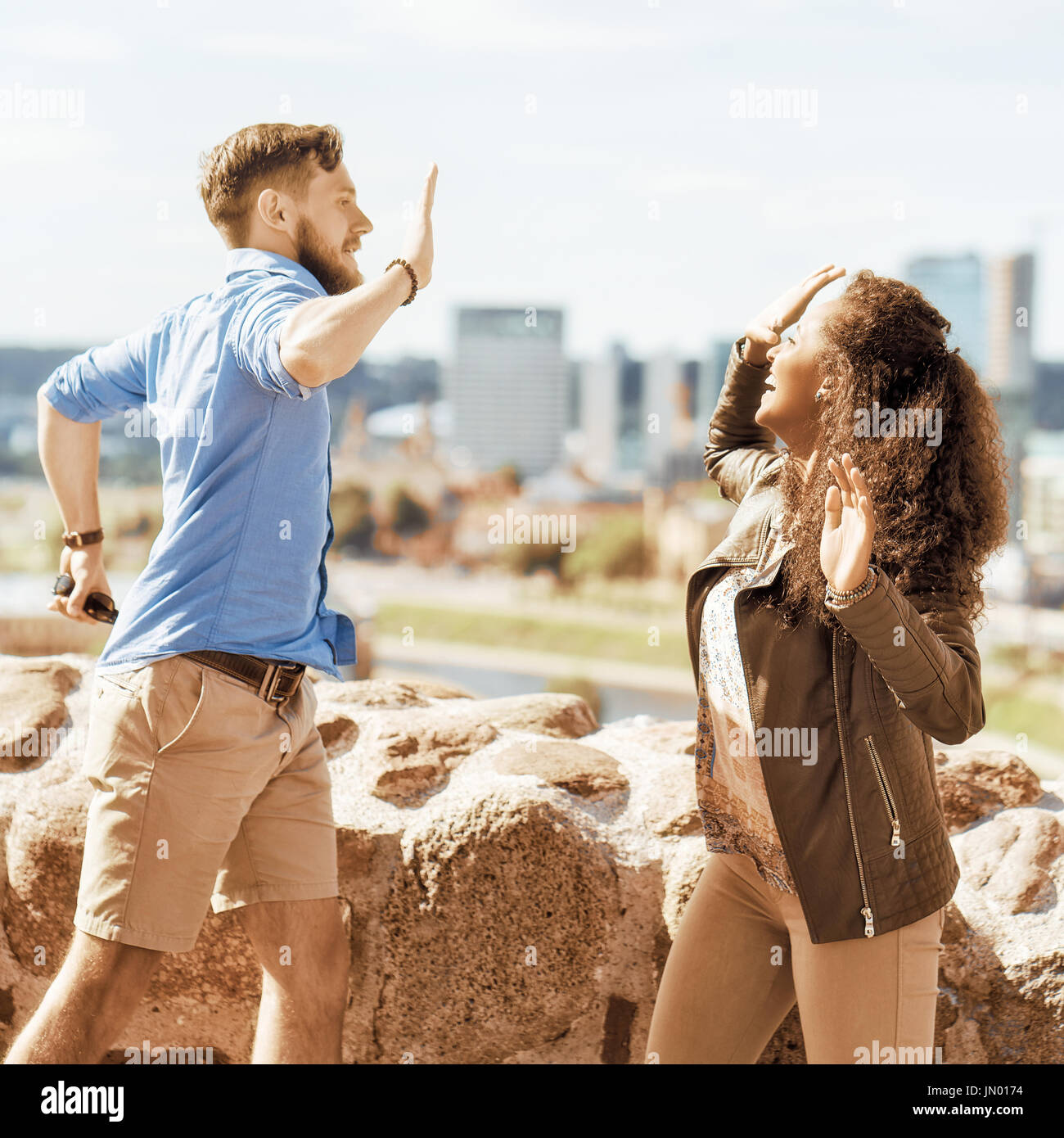 Young Smiling Multiracial Couple Having Fun And Clapping Their Hands As
