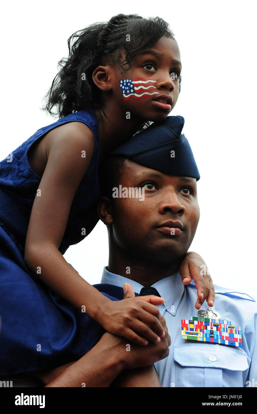 Air Force Tech Sergeant Marquis Mullins and his daughter Anya listen as ...