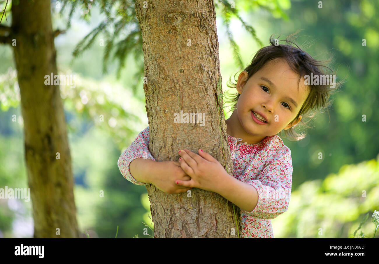 Little girl hugging the tree Stock Photo - Alamy