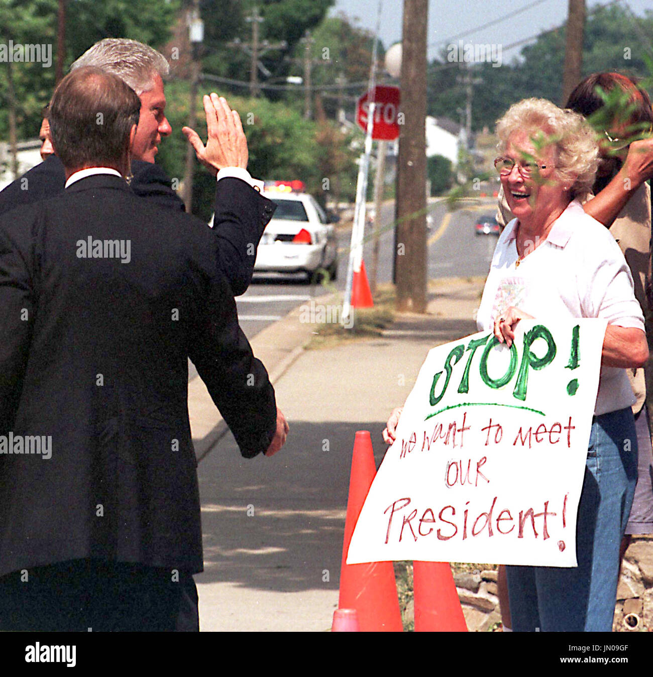 United States President Bill Clinton waves to an unidentified woman for ...