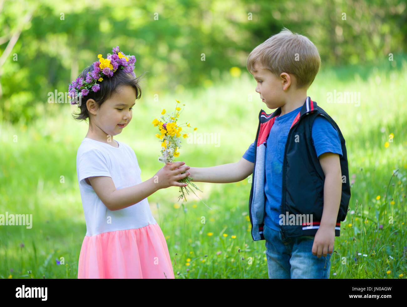 Little girl offering flower boy hi-res stock photography and images - Alamy