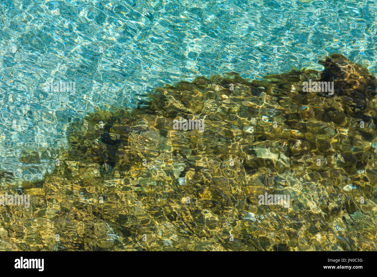 Blue sea ripple flowing water surface with waves and big stone on ...