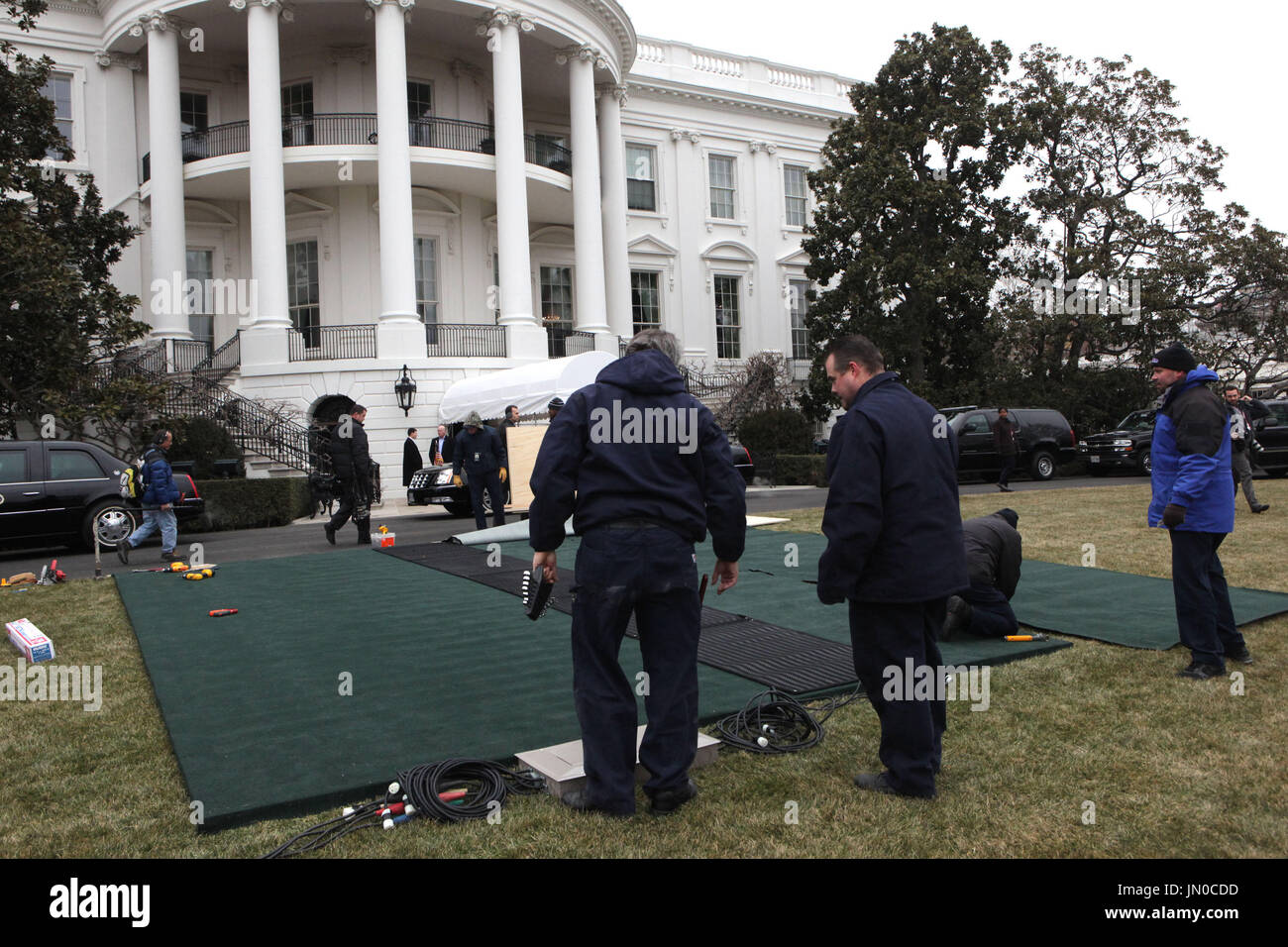 On the South Lawn of the White House workers install part of a ramp for ...