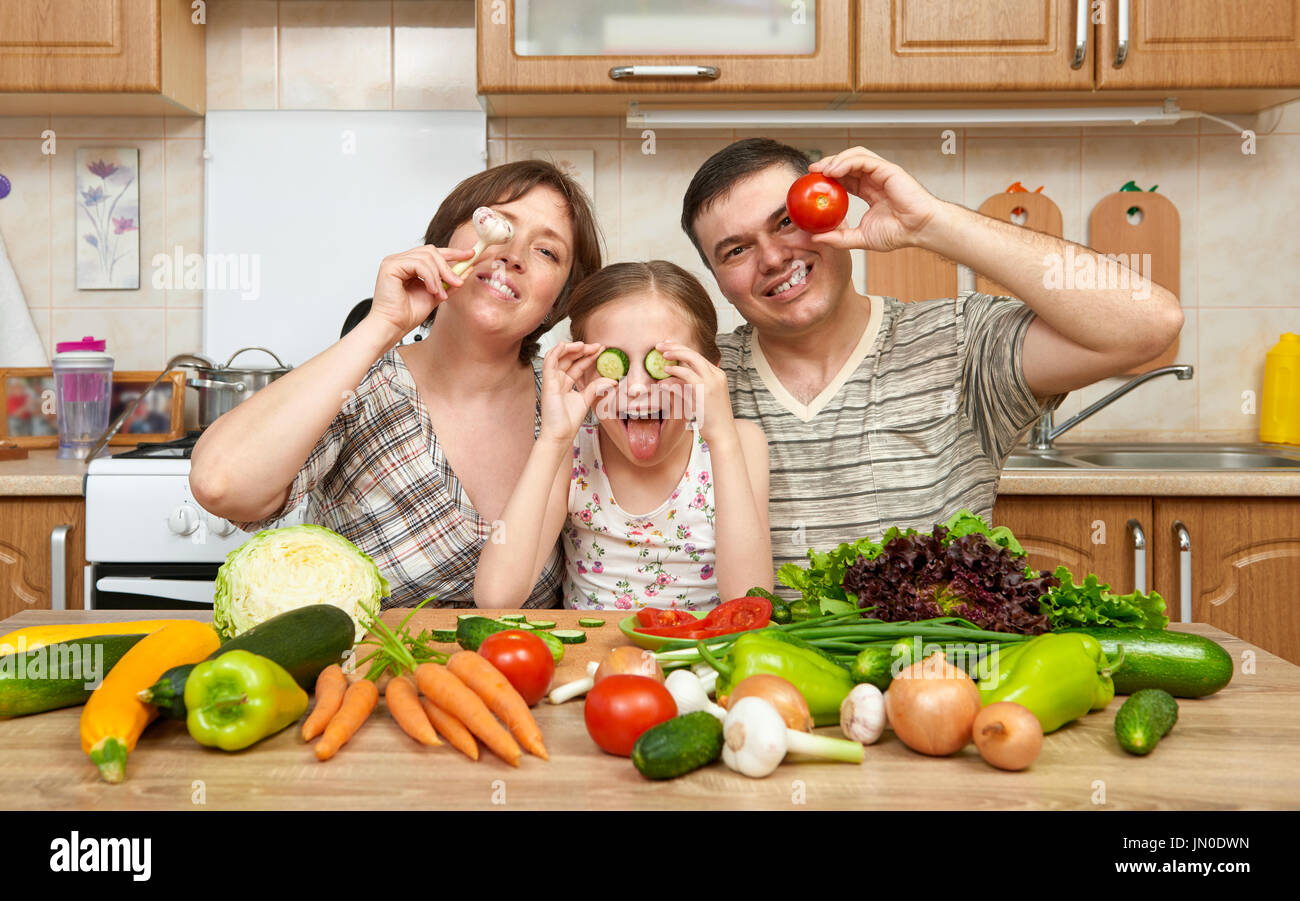 family cooking in kitchen interior at home, fresh fruits and vegetables ...