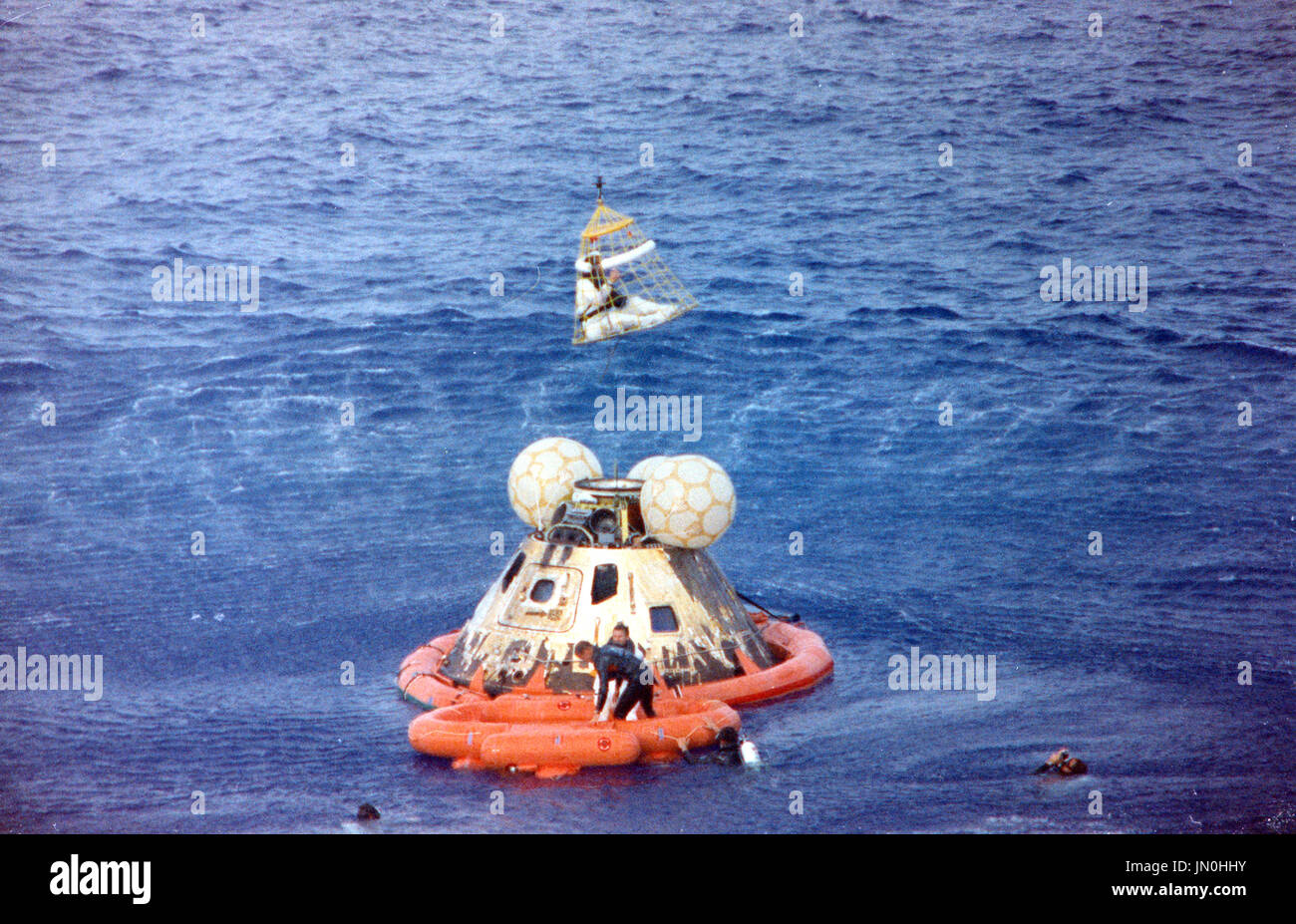 Astronaut John L. Swigert Jr., command module pilot, is lifted aboard a ...