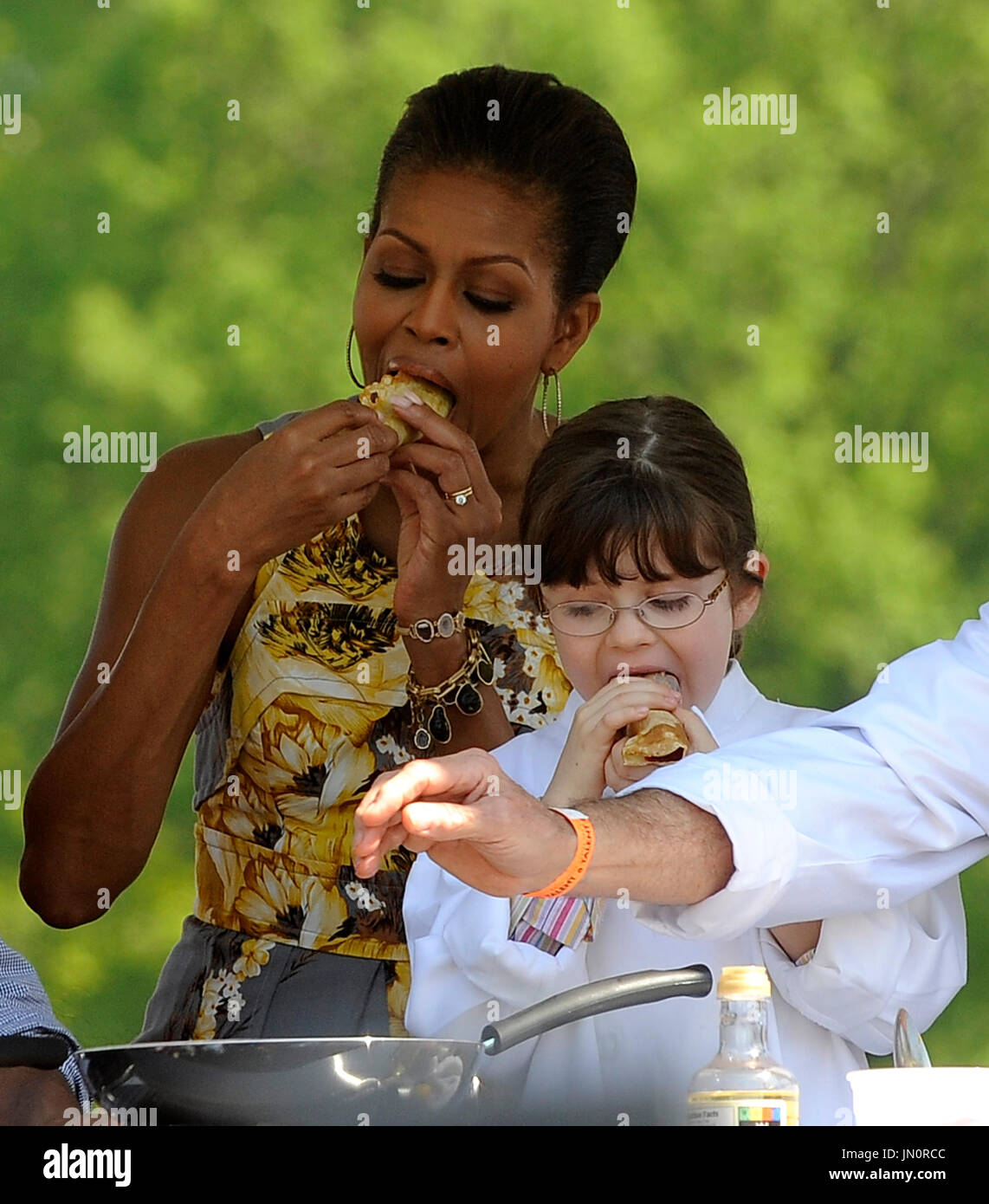 First Lady Michelle Obama eats a crepe at a cooking station during the ...