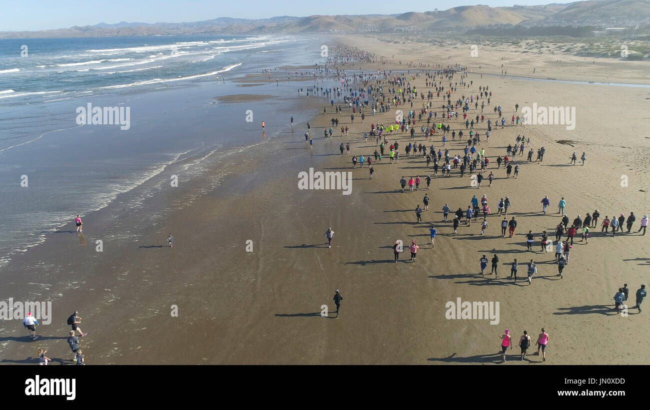 Aerial view of marathon runners alone the ocean shoreline Stock Photo ...