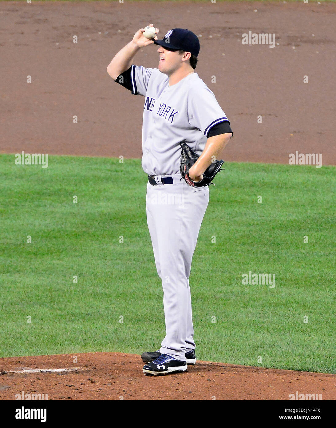 New York Yankees pitcher Phil Hughes (65) adjusts his cap as he works ...