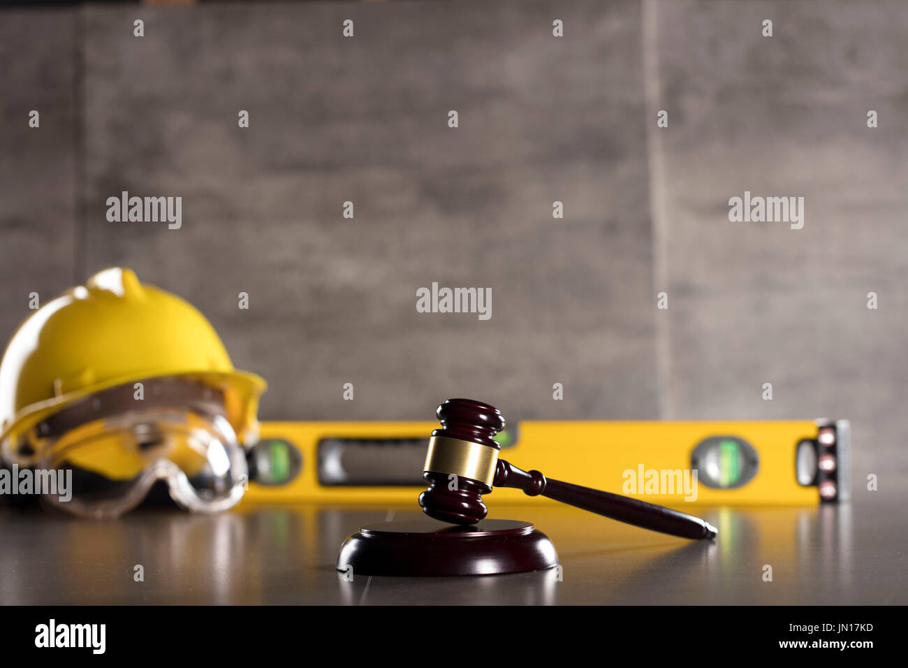 Construction law. Helmet and gavel. Stone table Stock Photo - Alamy