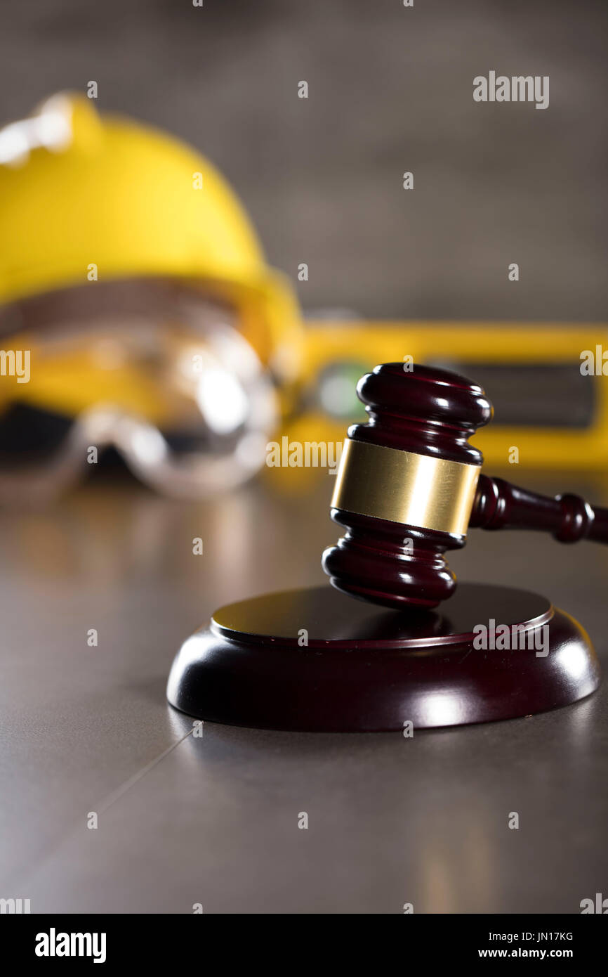 Construction law. Helmet and gavel. Stone table Stock Photo - Alamy