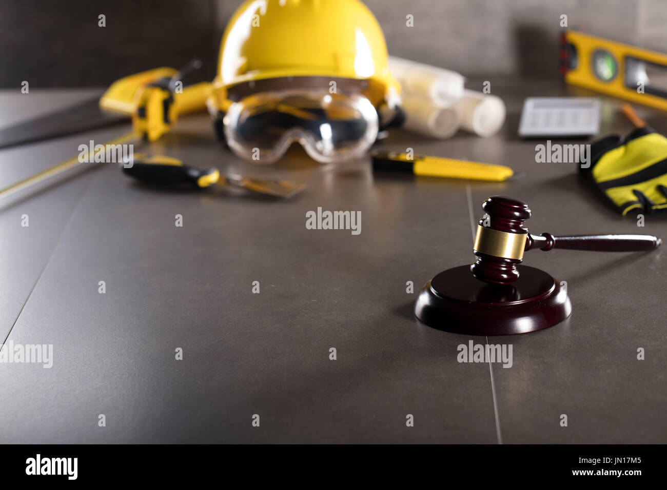 Construction law. Helmet and gavel. Stone table Stock Photo - Alamy